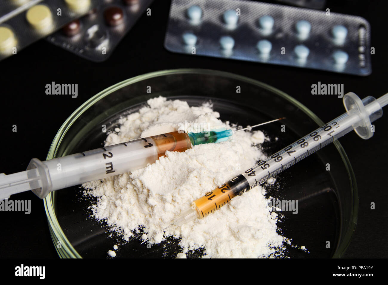 Drugs and syringes on dark table. Opioid epidemic Stock Photo - Alamy