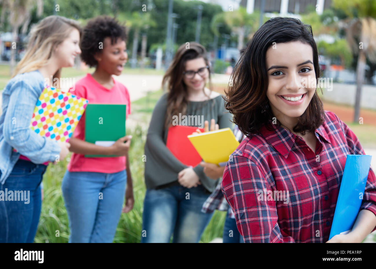 Hispanic female student with group of international students outdoors ...