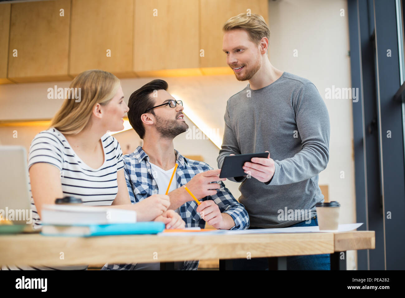 Modern device. Smart nice young man standing together with his friends ...