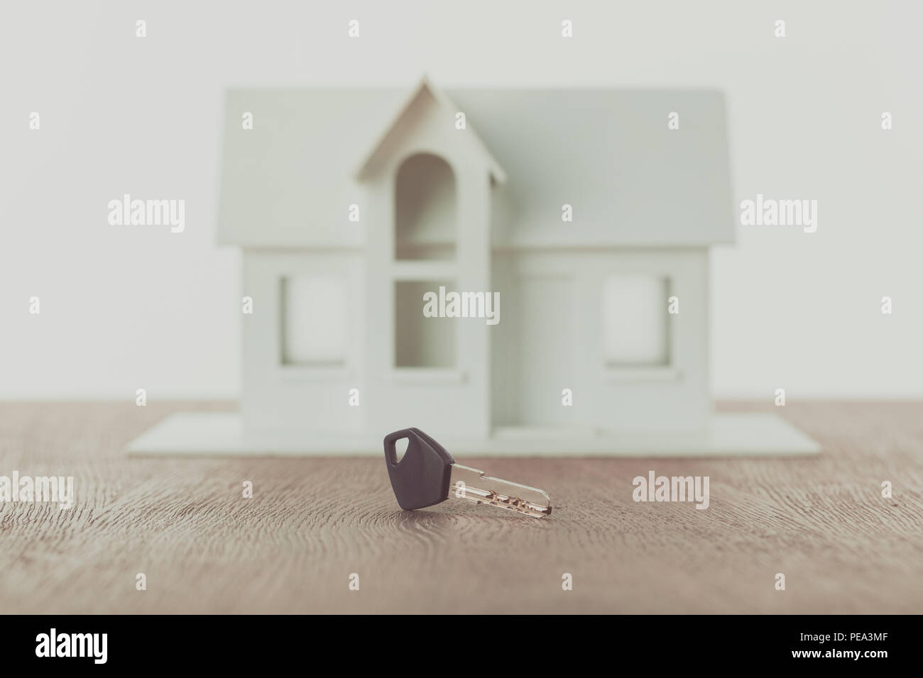 key and small wooden house on tabletop, saving concept Stock Photo - Alamy