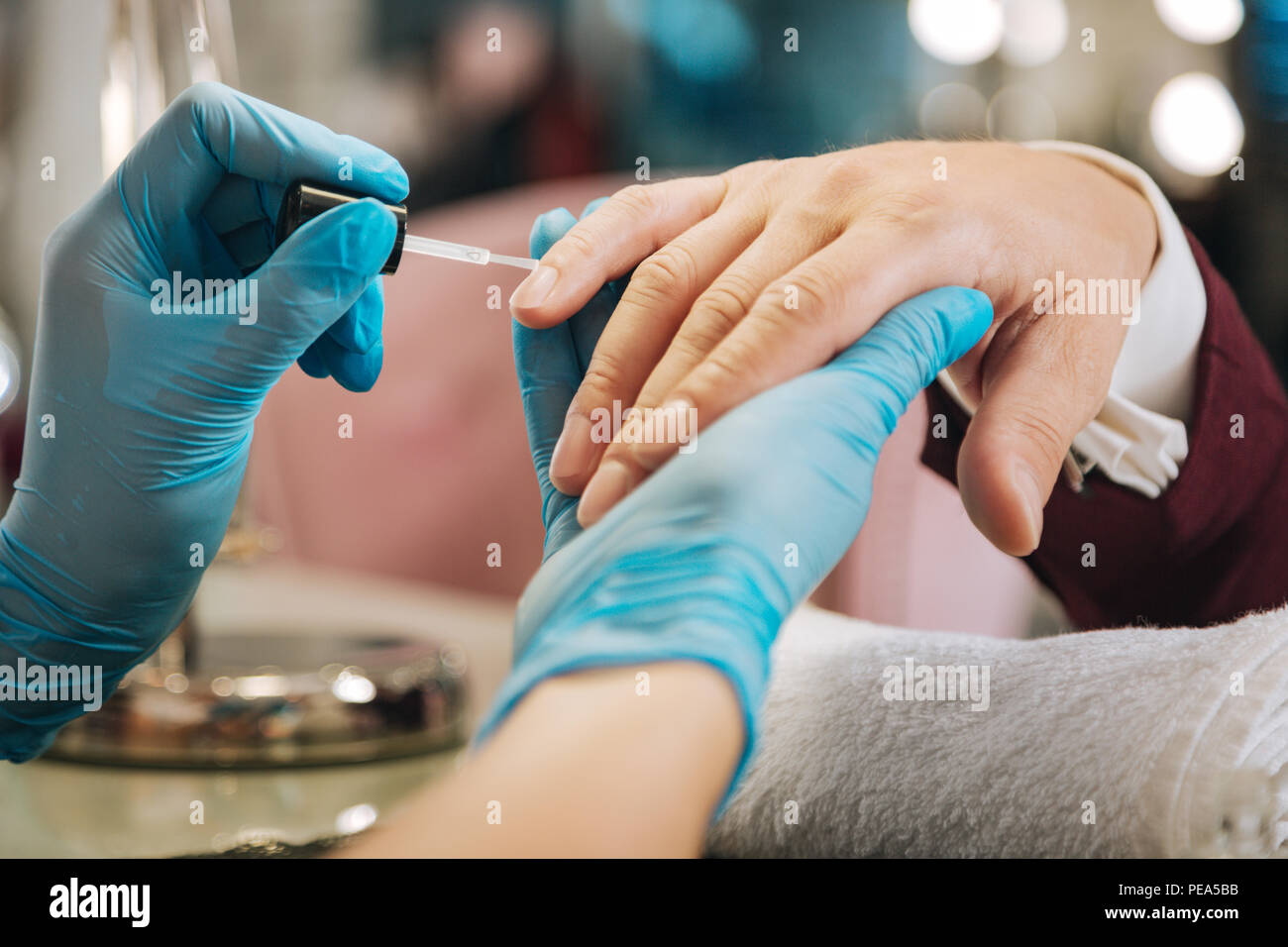 Female hands moisturizing male hands clouse up Stock Photo - Alamy