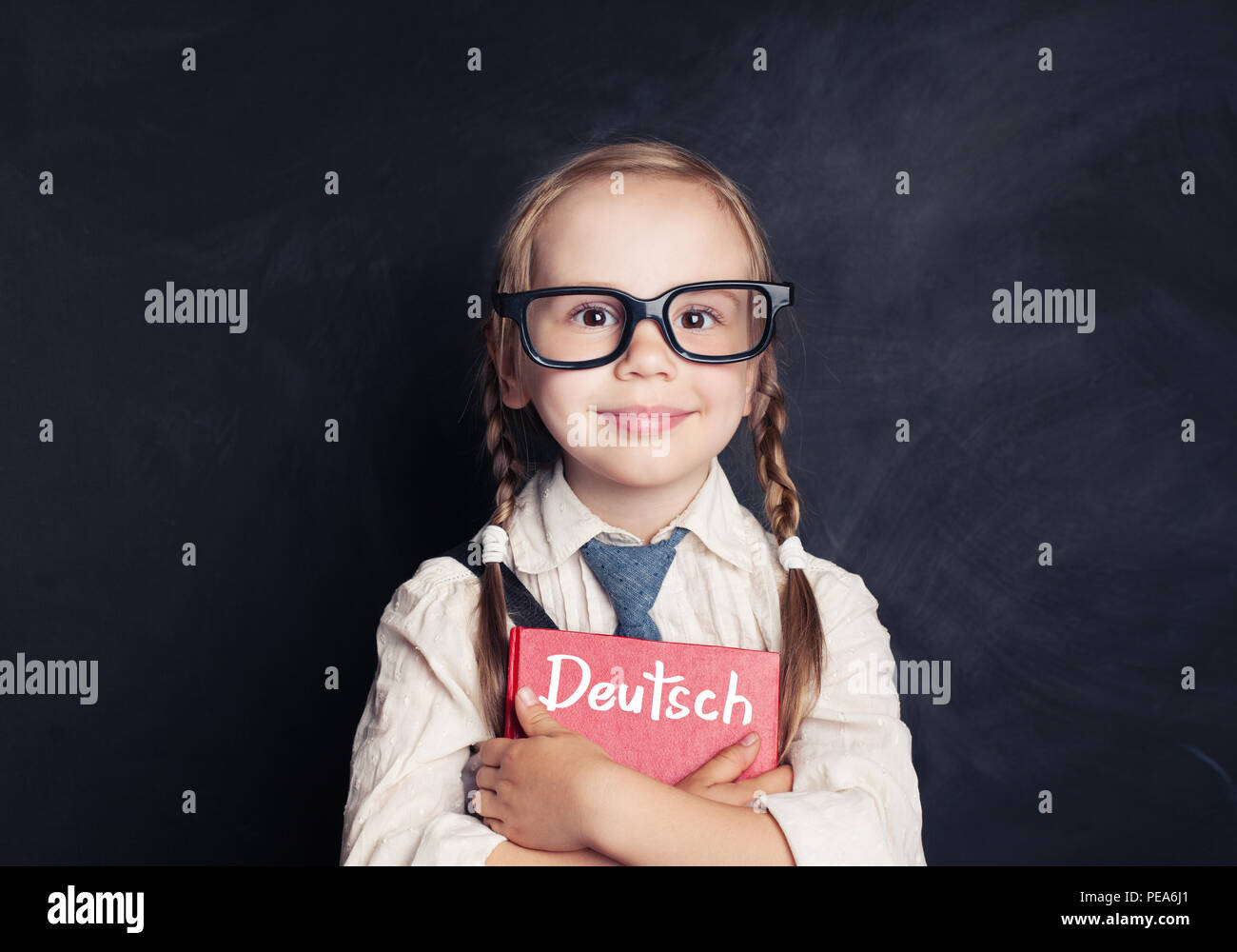German language concept. Cute child pupil with german book smiling in ...