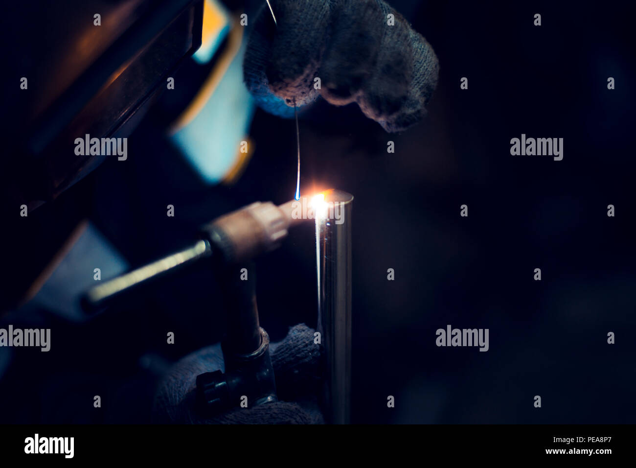 The welder lights the arc and begins to weld the metal structure of ...