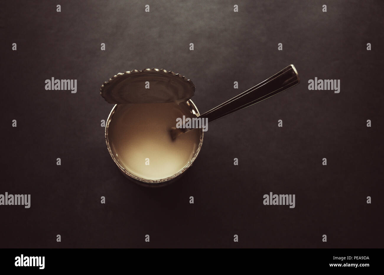 iron tin of condensed milk with spoon on grey background, vintage image ...