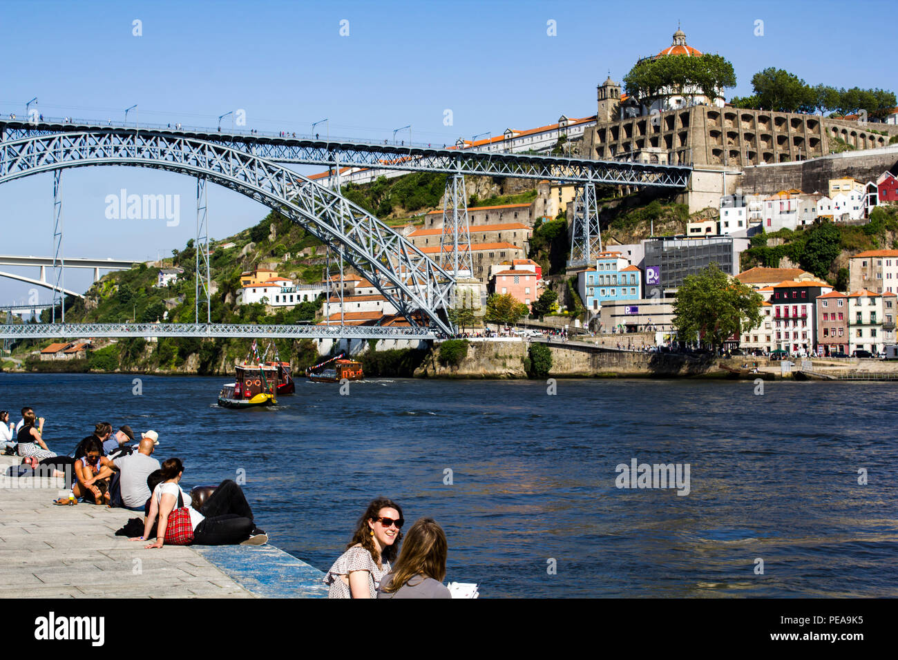 People relaxing at riverside quay Stock Photo - Alamy