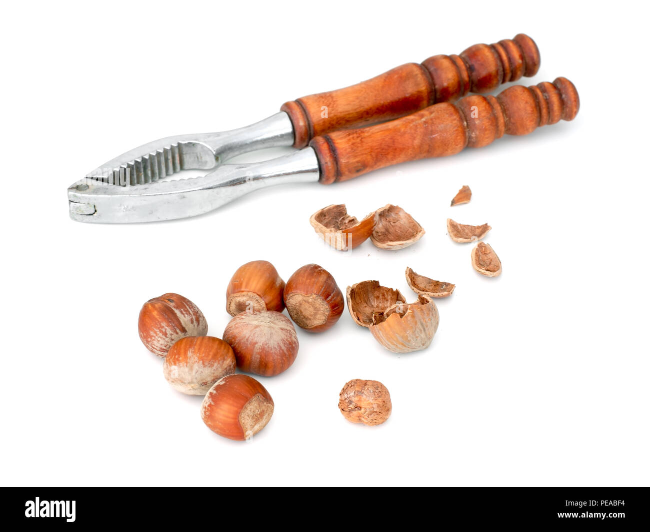 Low angle closeup of hazelnuts with nutcrackers on white Stock Photo ...