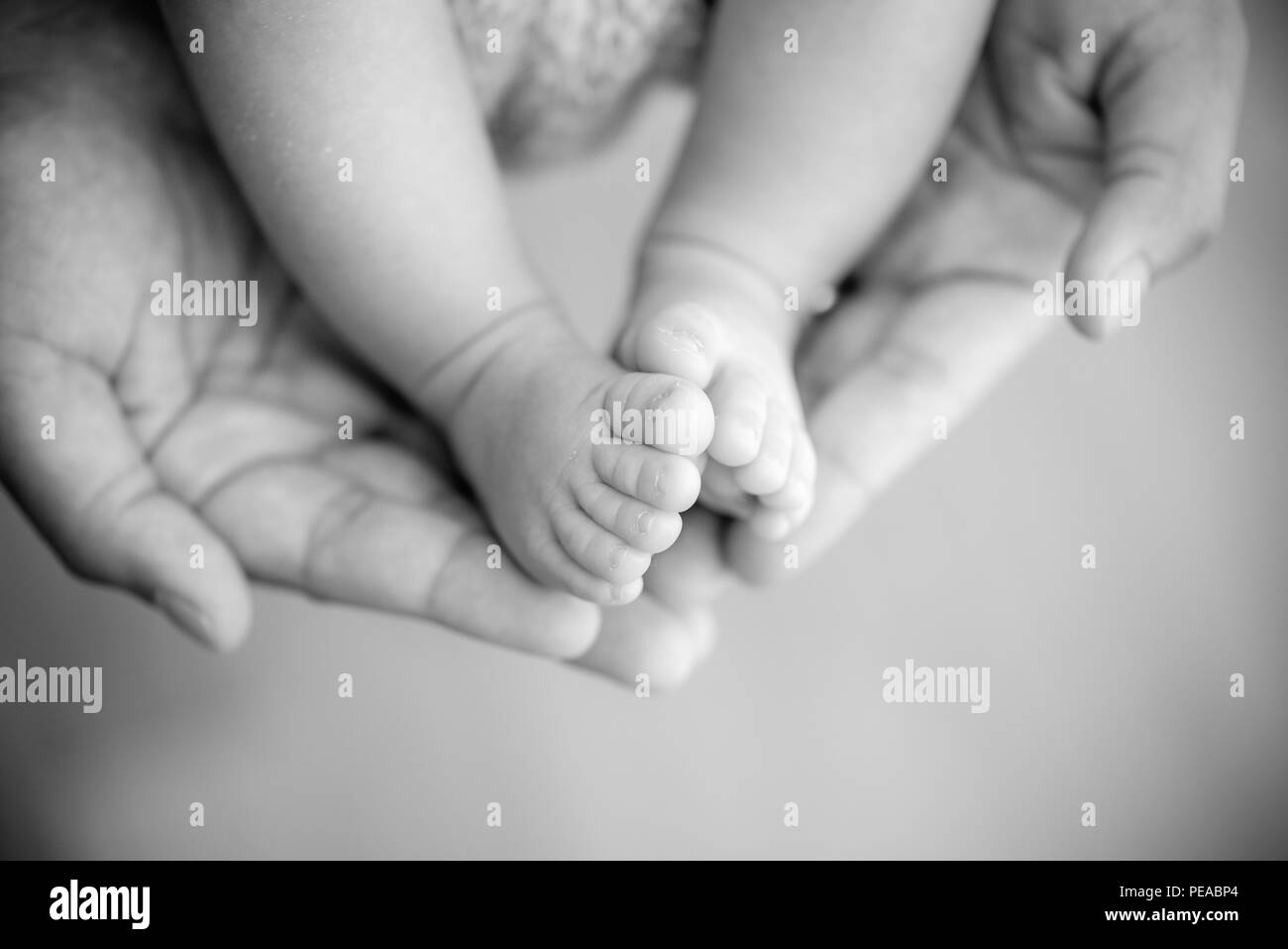 Feet of a newborn baby in the hands of parents. Happy Family oncept ...