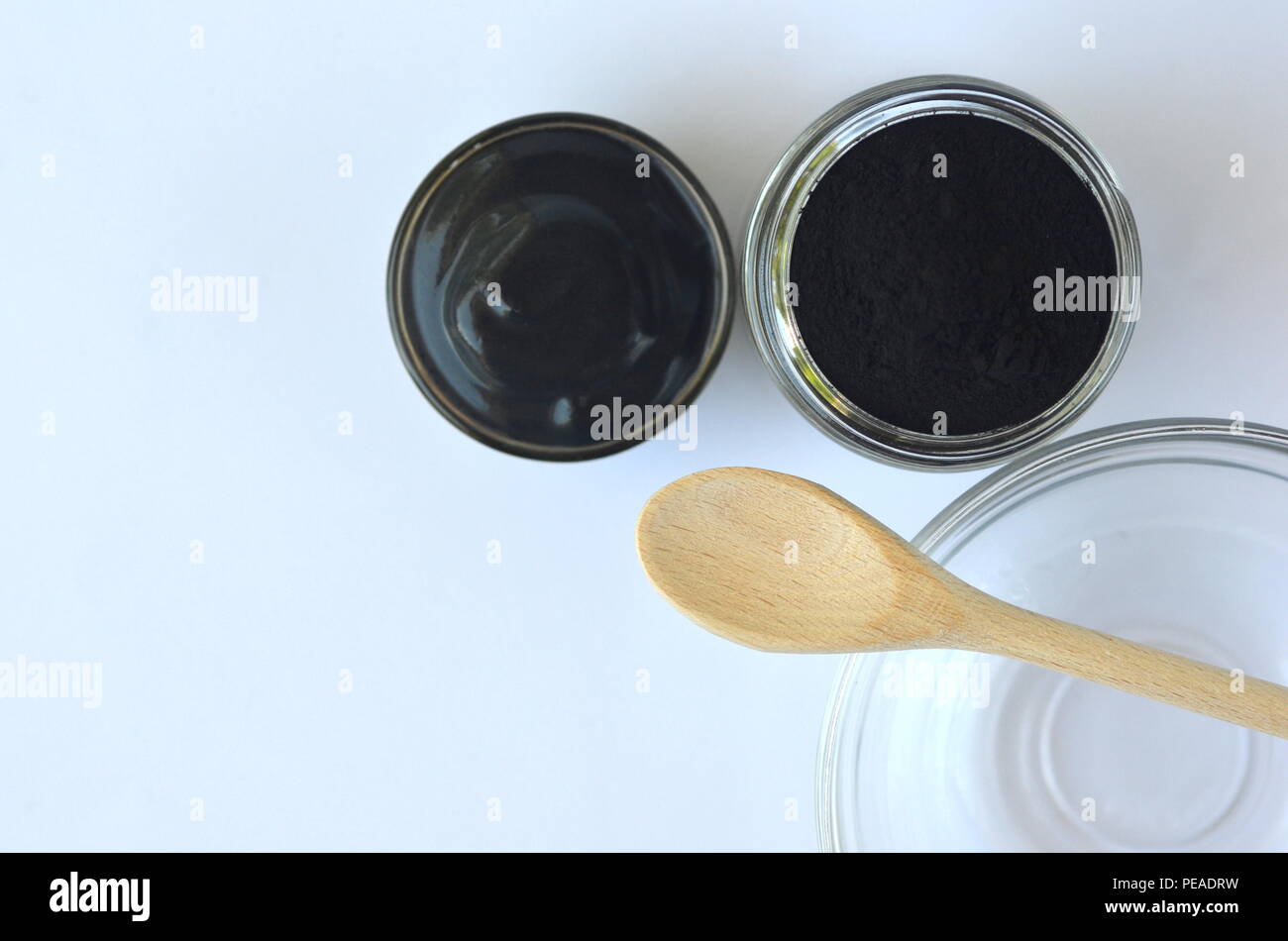 Cosmetic activated charcoal powder in a glass jar and beauty face mask ...