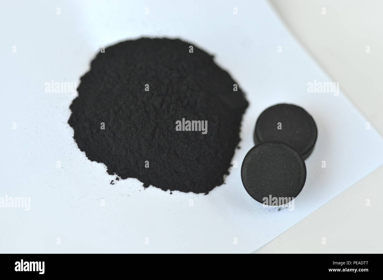 Cosmetic activated charcoal powder in a glass jar and beauty face mask ...