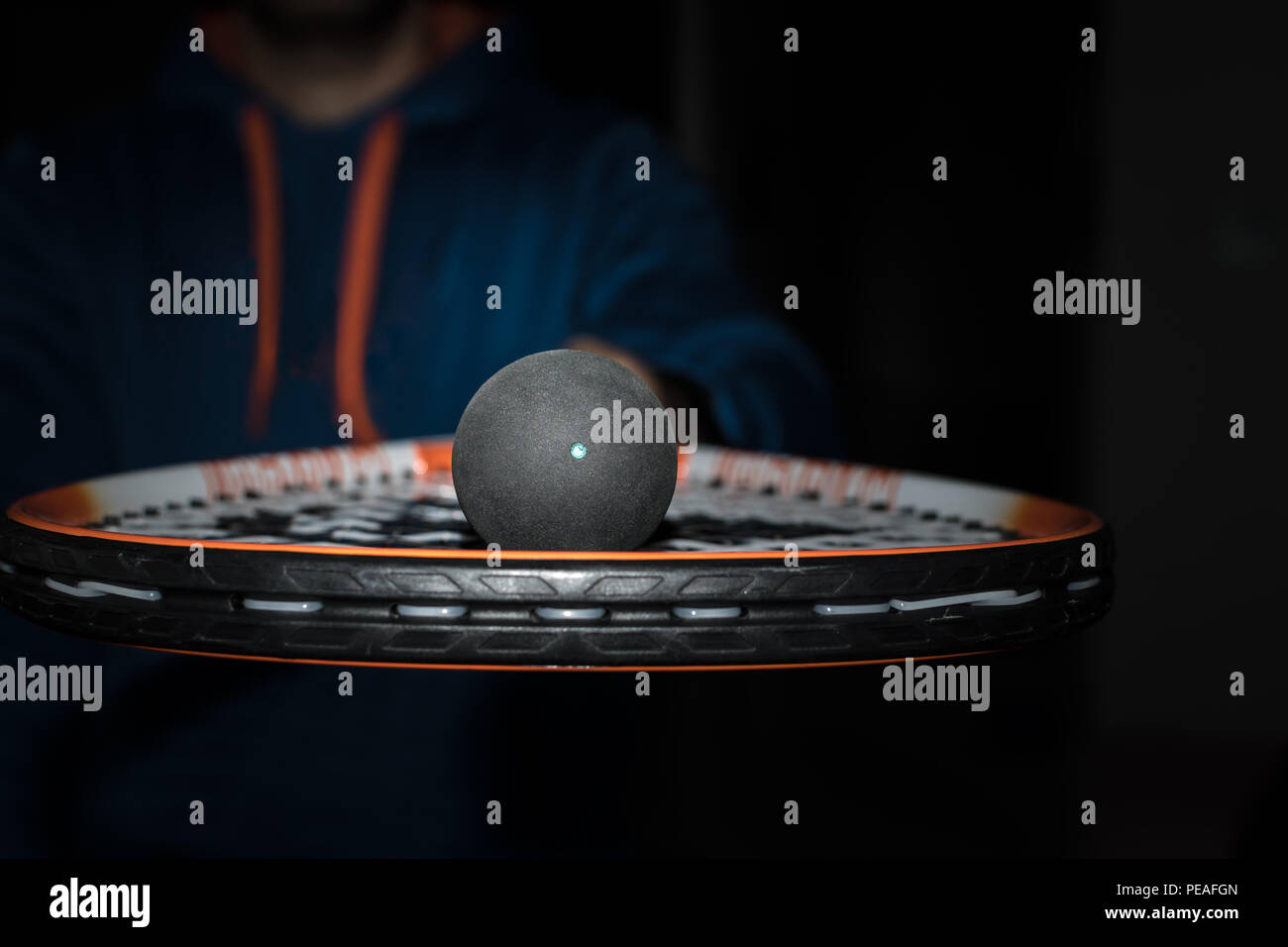 Single dot squash ball on the strings of a racquet Stock Photo - Alamy