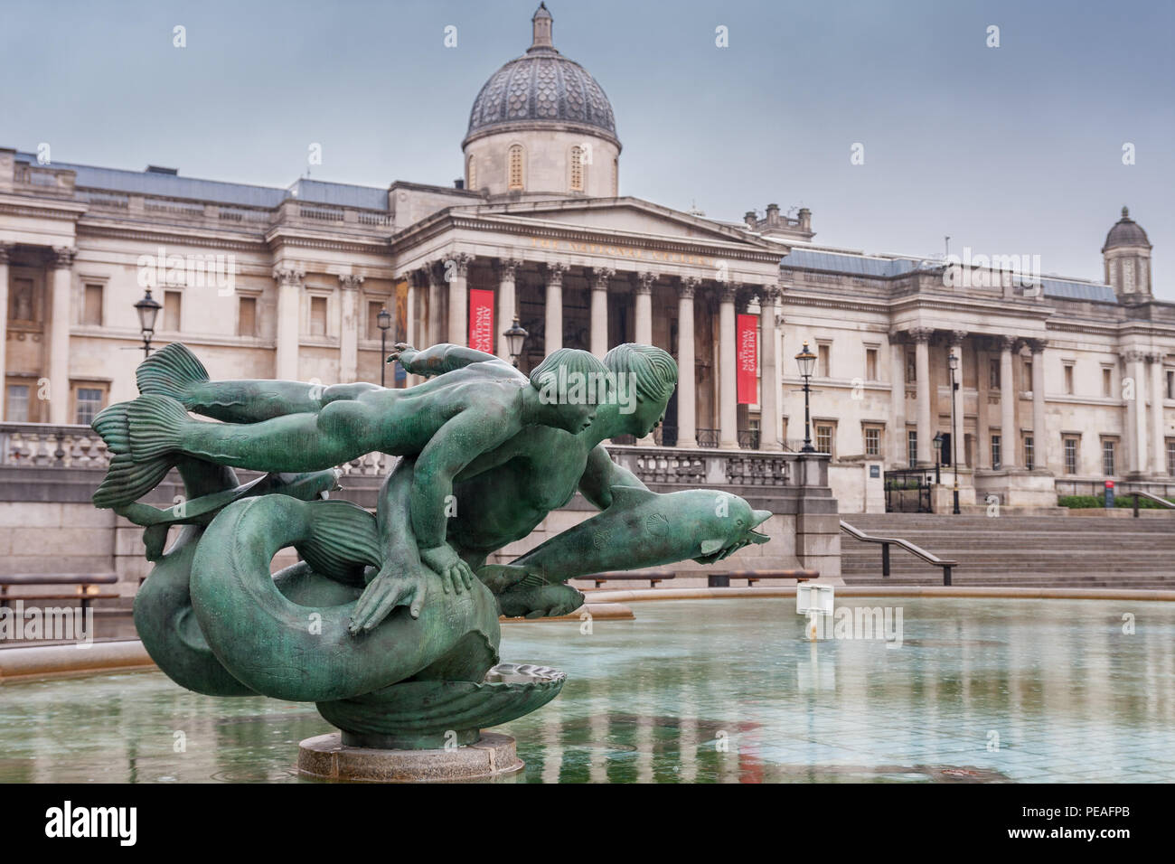 Mermaid statues on fountain on Trafalgar square in rainy early morning ...