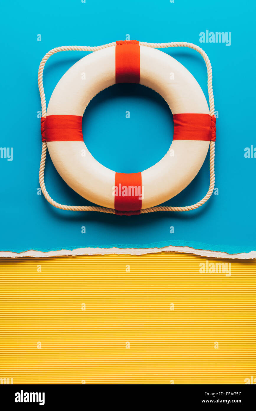 top view of red and white life saver on blue and yellow paper ...