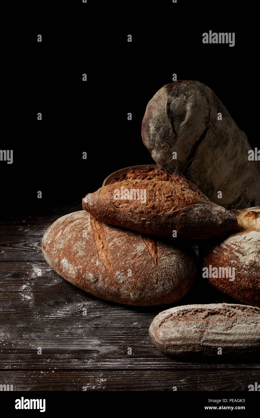 closeup view of various types of bread on wooden table covering by ...