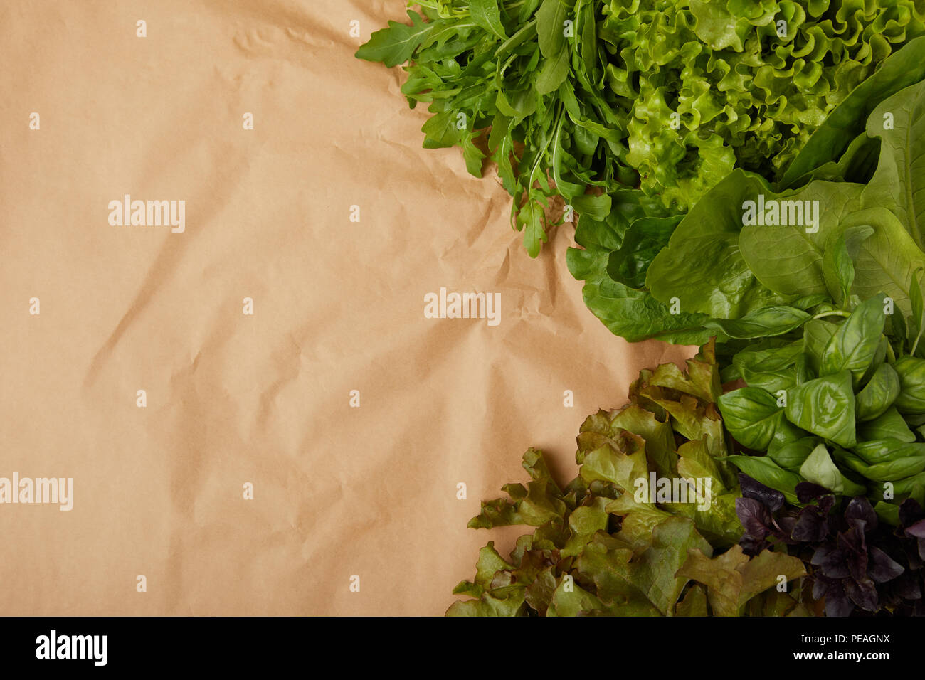 top view of fresh various leaf vegetables on crumpled paper Stock Photo ...