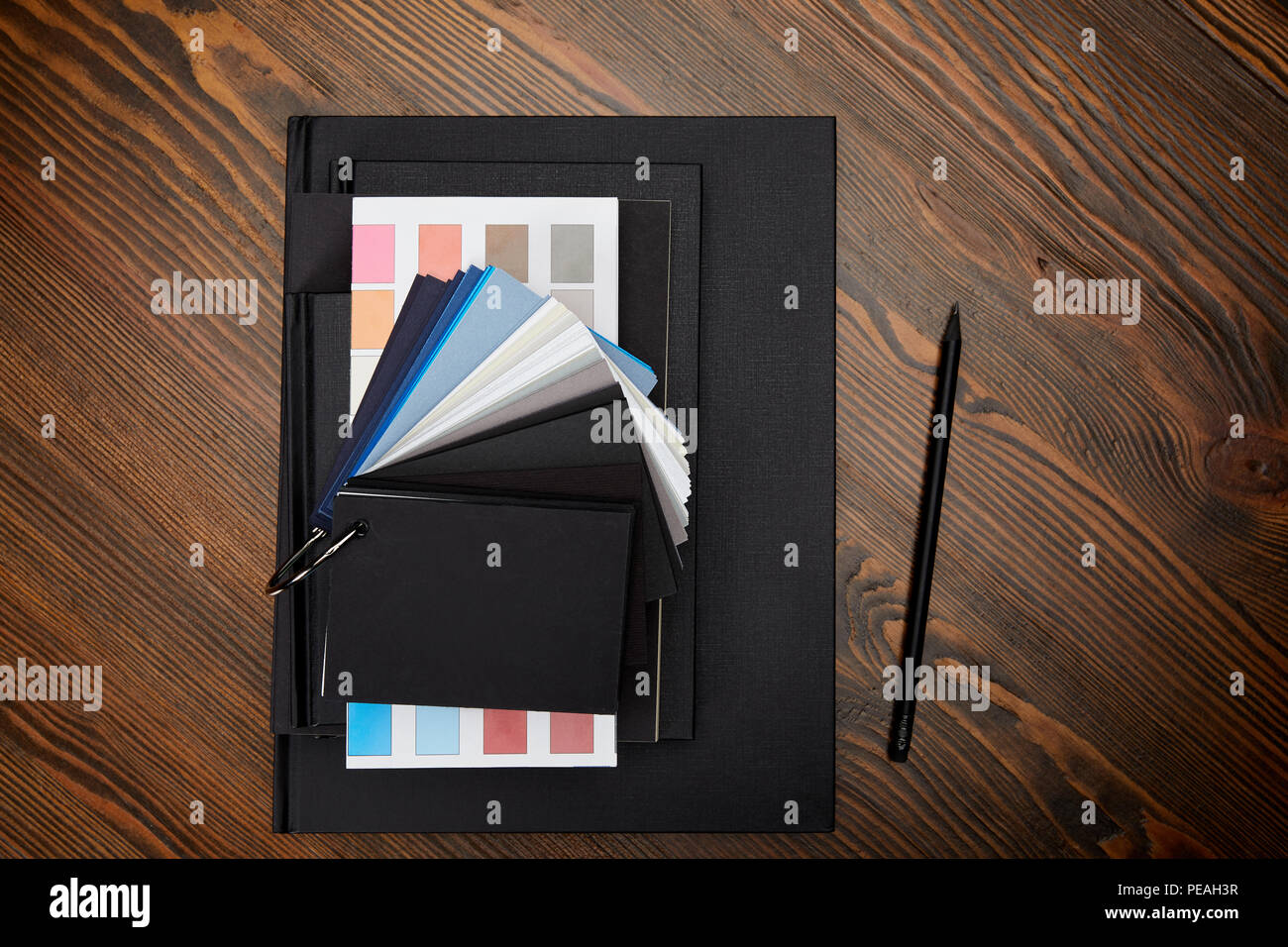 flat lay with black notebooks, colors pallet and pencil on wooden ...