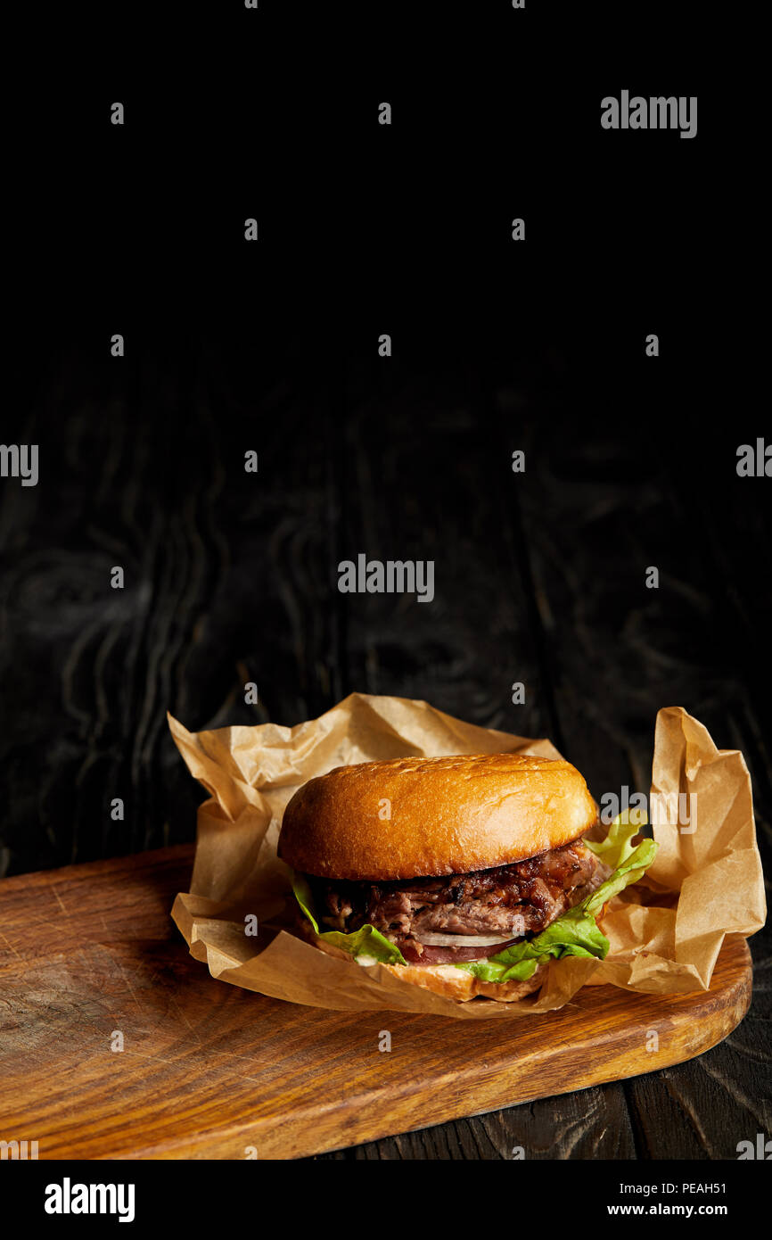 Tempting fast food diner with hamburger on wooden board Stock Photo - Alamy