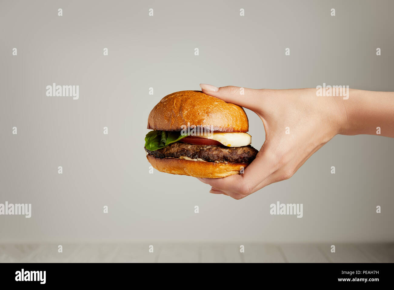 Fat burger in hand hi-res stock photography and images - Alamy
