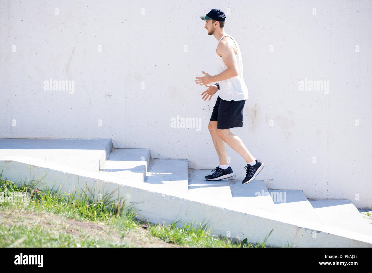 Side view full length portrait of muscular young man running up and ...