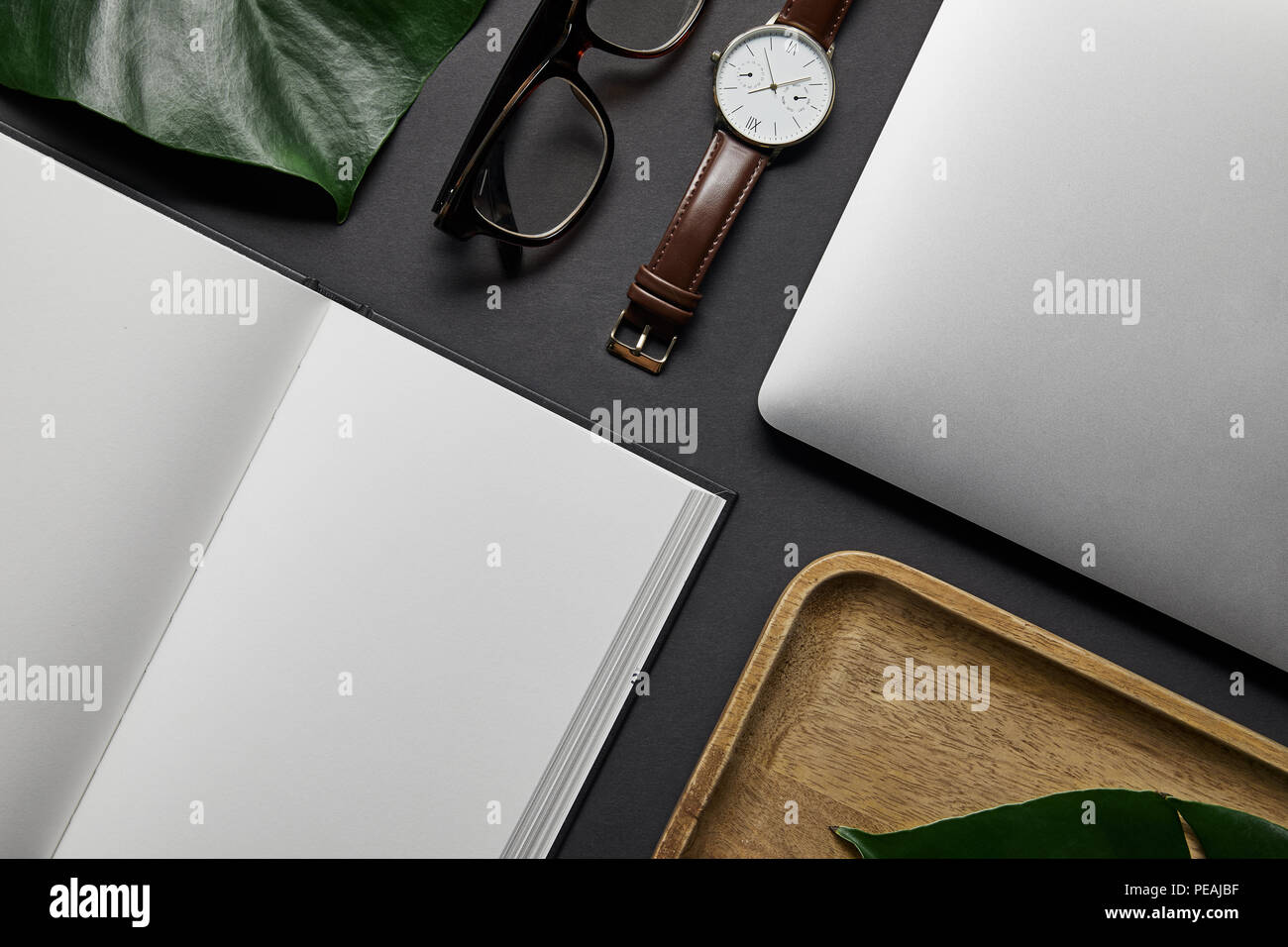 Flat lay template with open notebook and laptop on black background ...