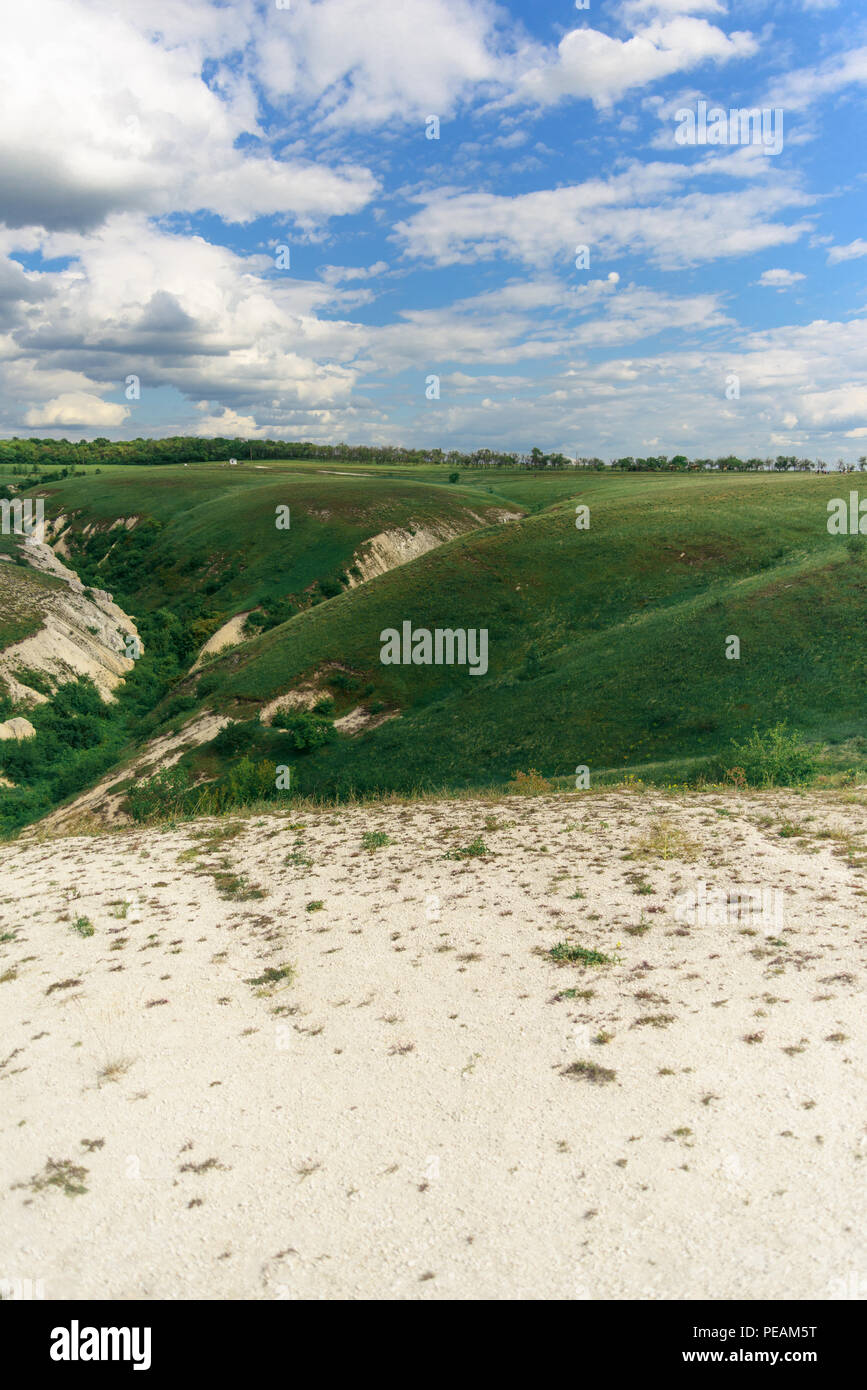 Beautiful view of grassy ravine on sky background with clouds, vertical ...
