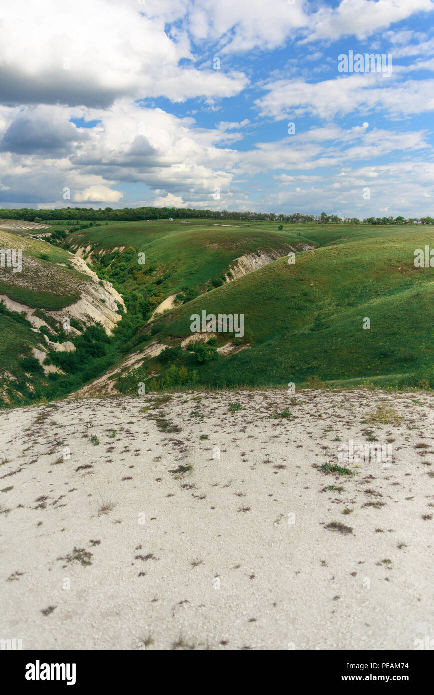 Beautiful view of grassy ravine on sky background with clouds, vertical ...