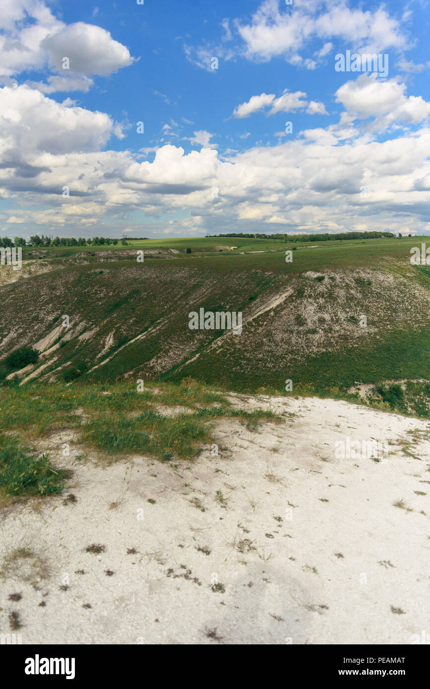 Beautiful view of grassy ravine on sky background with clouds, vertical ...