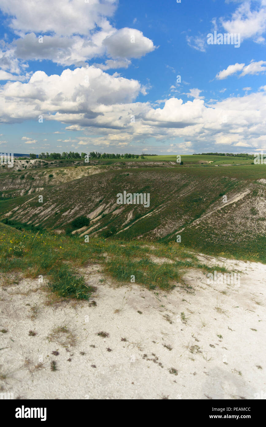 Beautiful view of grassy ravine on sky background with clouds, vertical ...