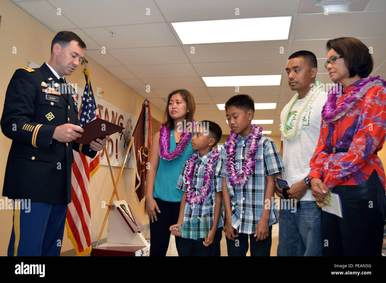 The Agno family listens to the Lt. Col. Patrick A. Disney, commander ...