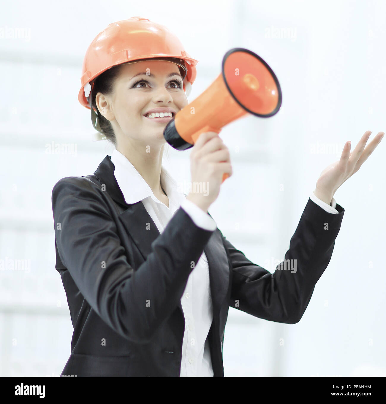 confident female engineer with a megaphone on the background of the ...