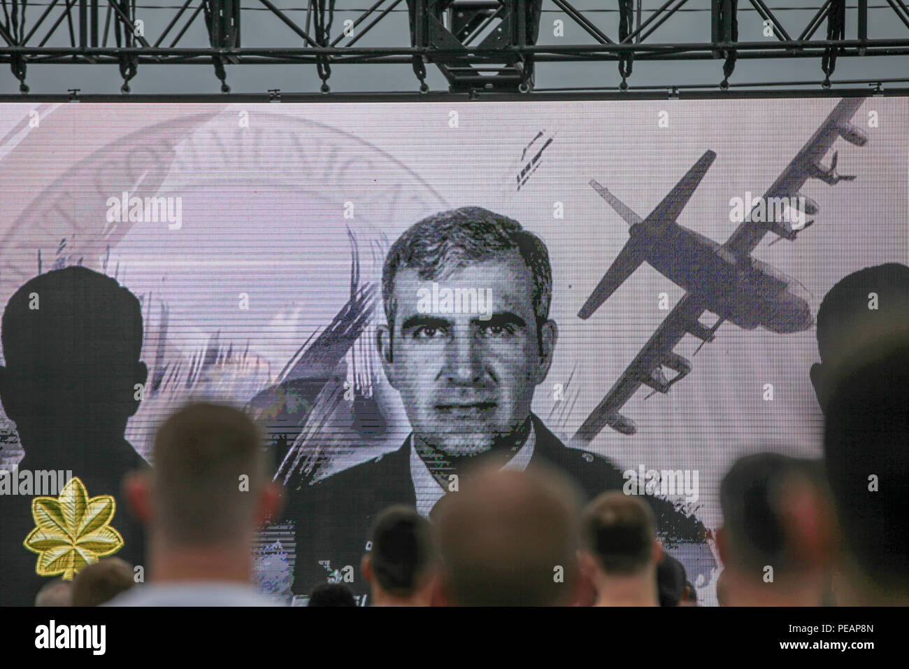 Participants and volunteers watch a memorial video during the opening ...