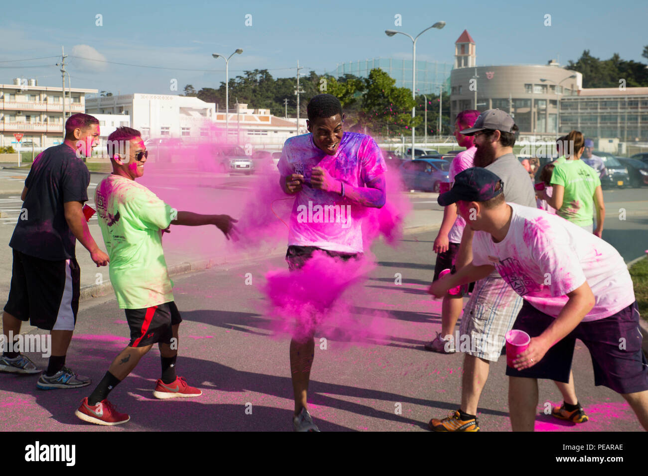 Volunteers cover a runner with colored powder on the last leg of the ...