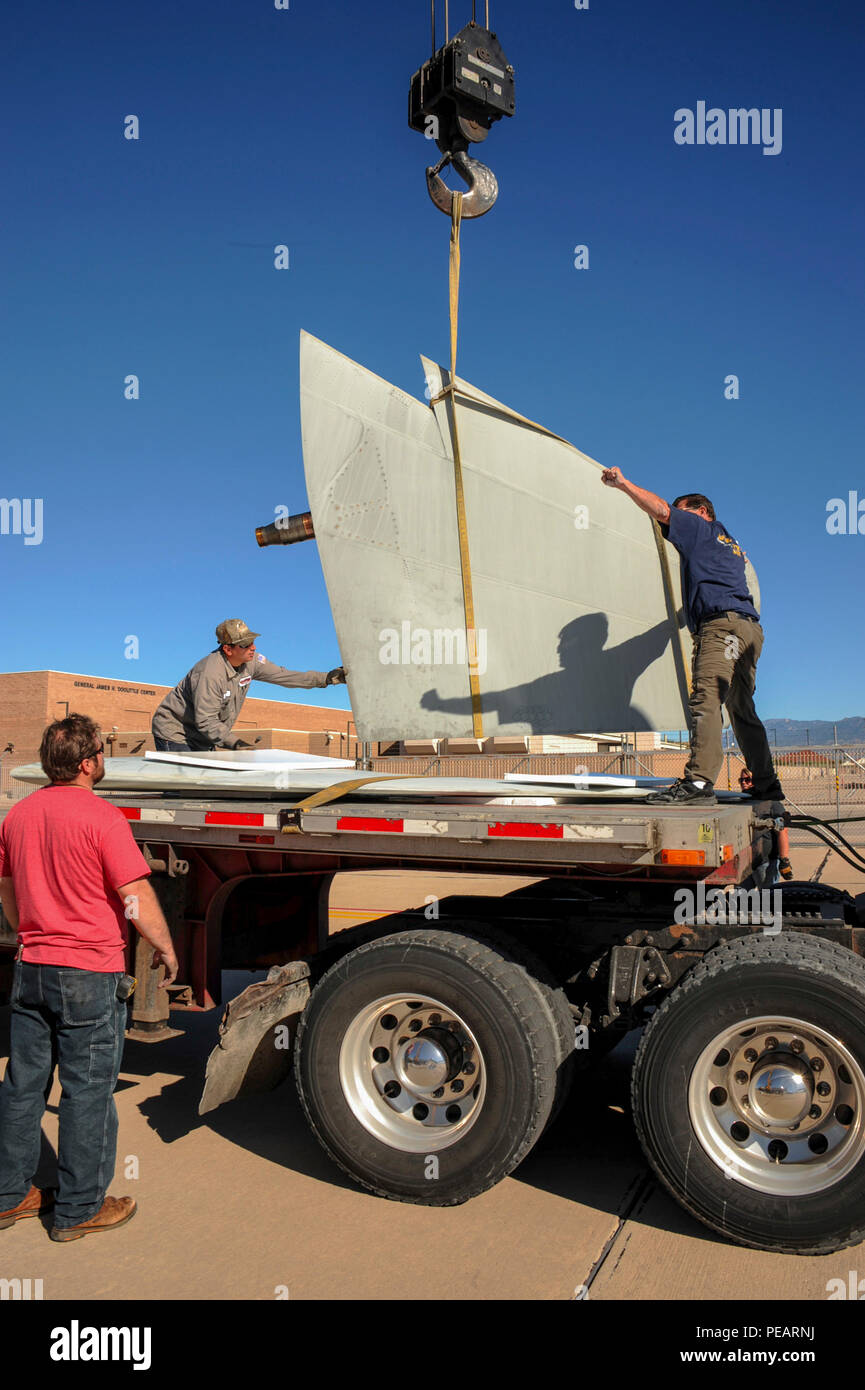 A team of contractors load an F-15A Eagle horizontal stabilizer onto a ...