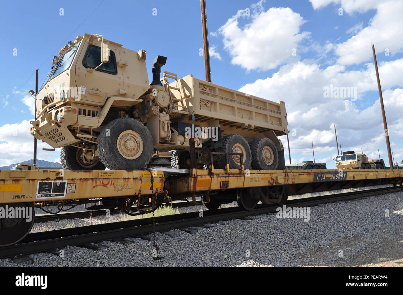 A five-ton dump truck is loaded onto the train for shipping, as a ...