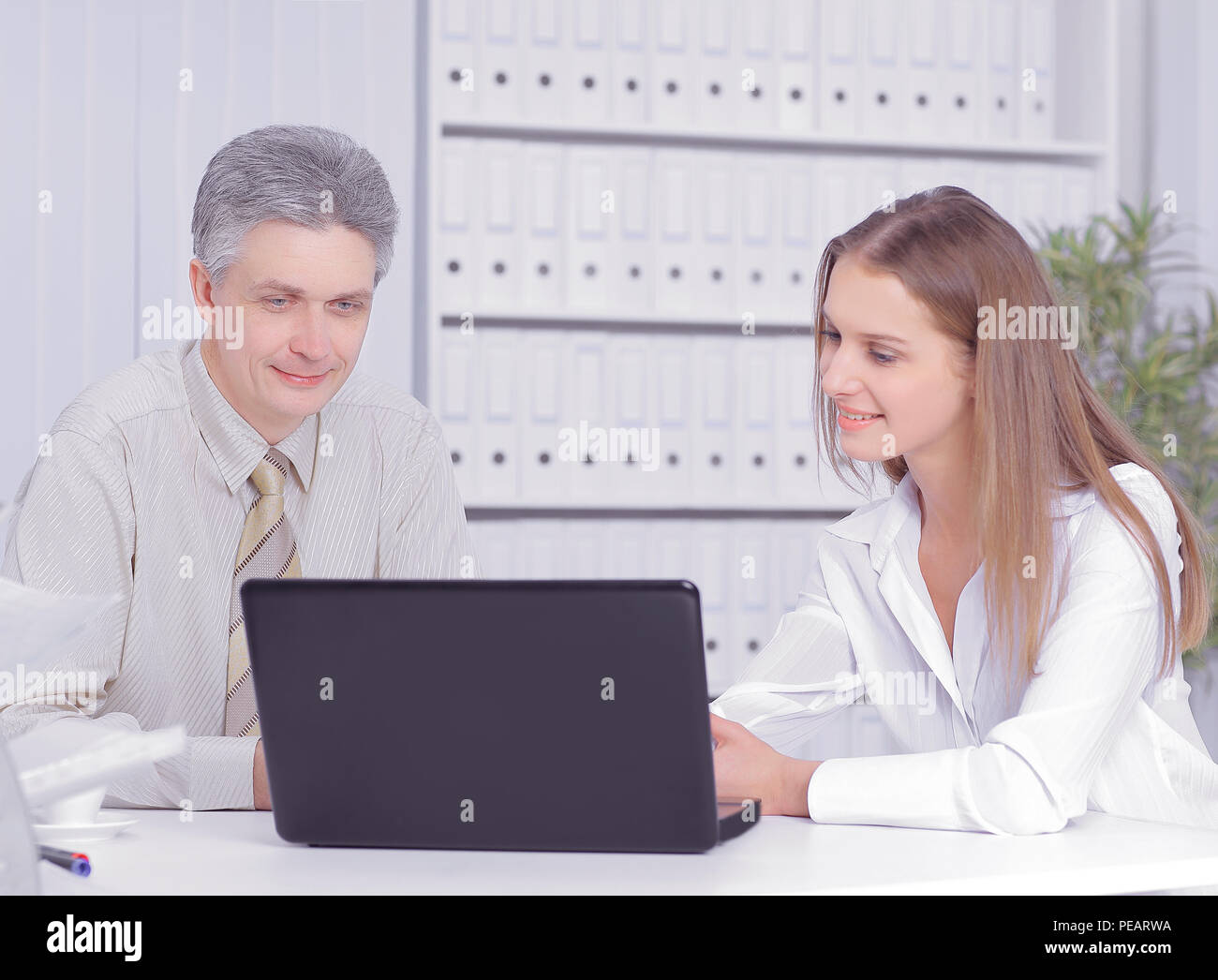 two members of the company sitting behind a Desk Stock Photo - Alamy