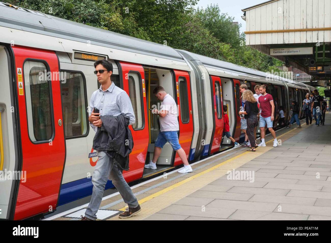 Commuters boarding a District line tube train at Wimbledon Park tube ...