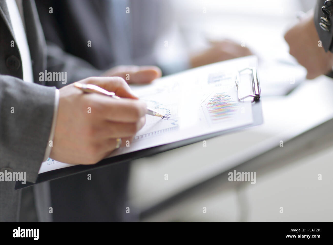 businessman at desk checking a financial report and pointing at a bar ...