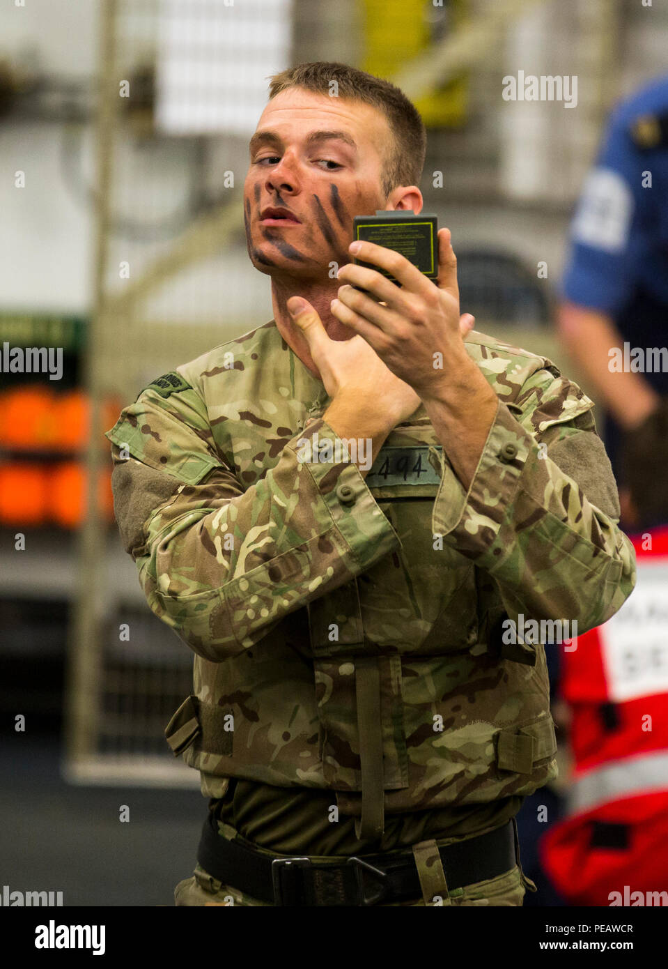 A U.K. Royal Marine with 45 Commando applies camouflage paint during a ...