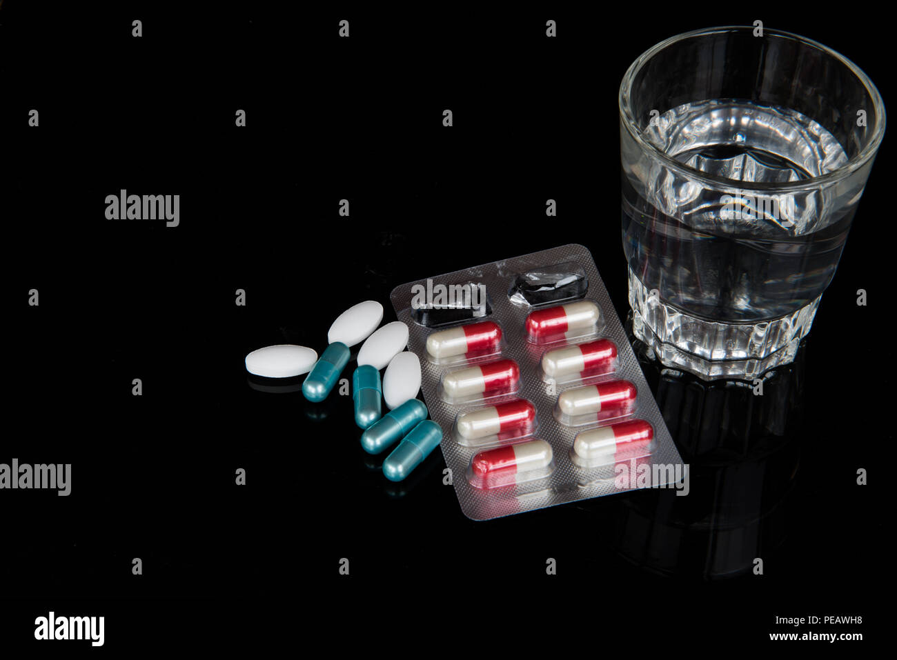 capsule and pill medication with water glass on black background Stock ...