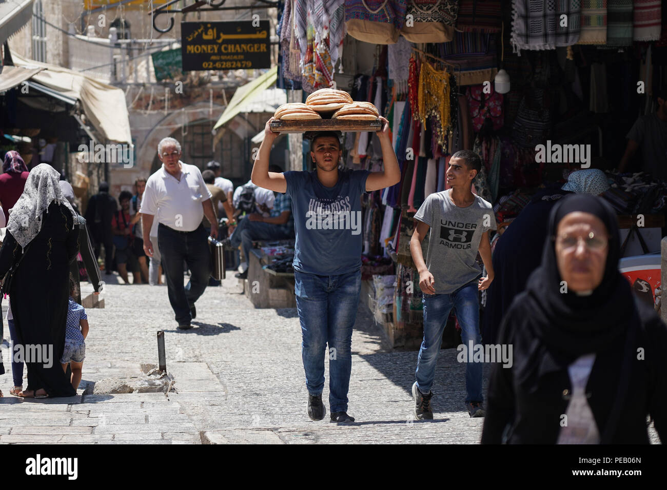 A man carrying traditional bread on his head in the Palestinian quarter ...