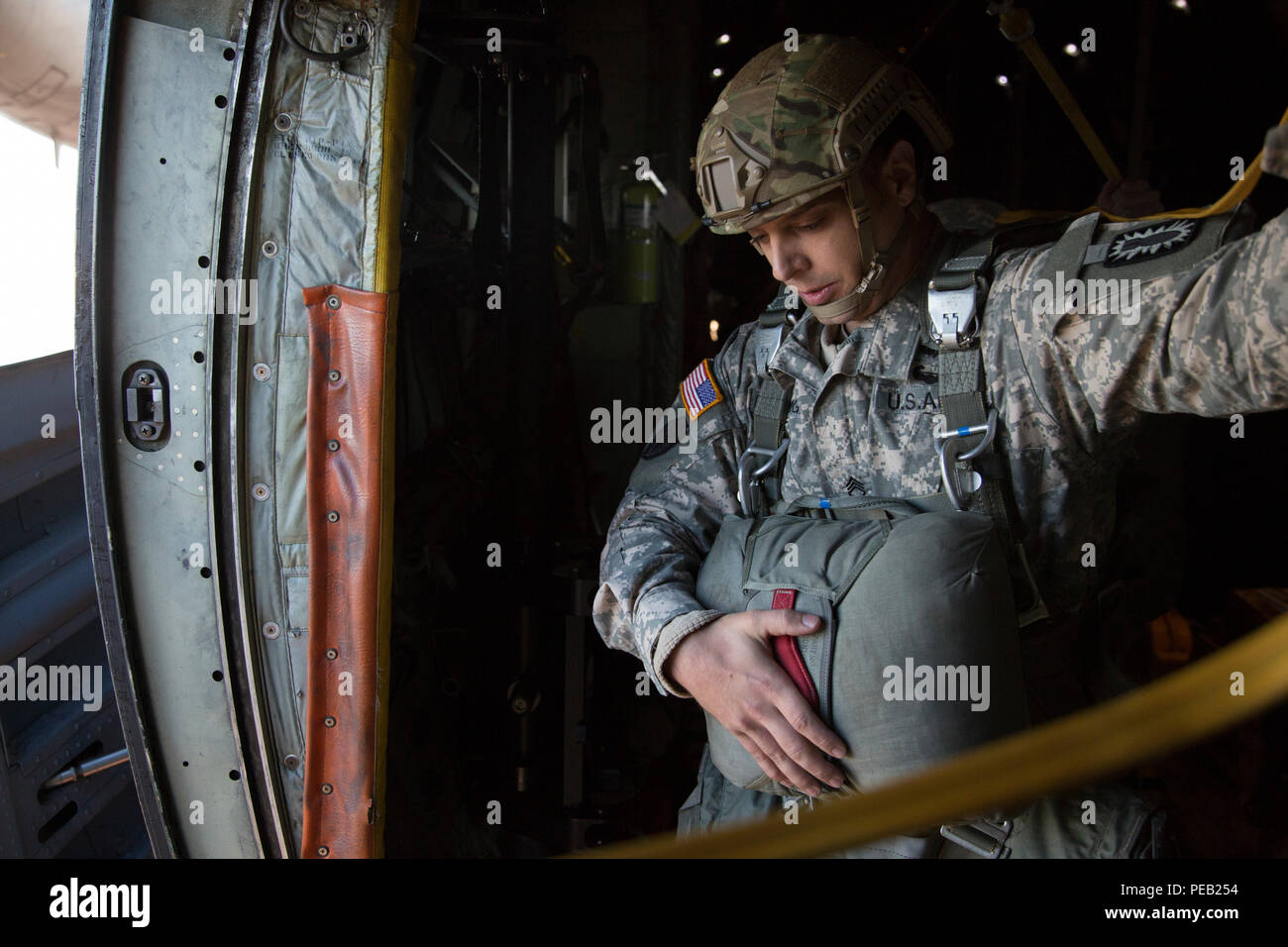 A U.S. Army paratrooper jumps out the door of a C-130 Hercules during ...
