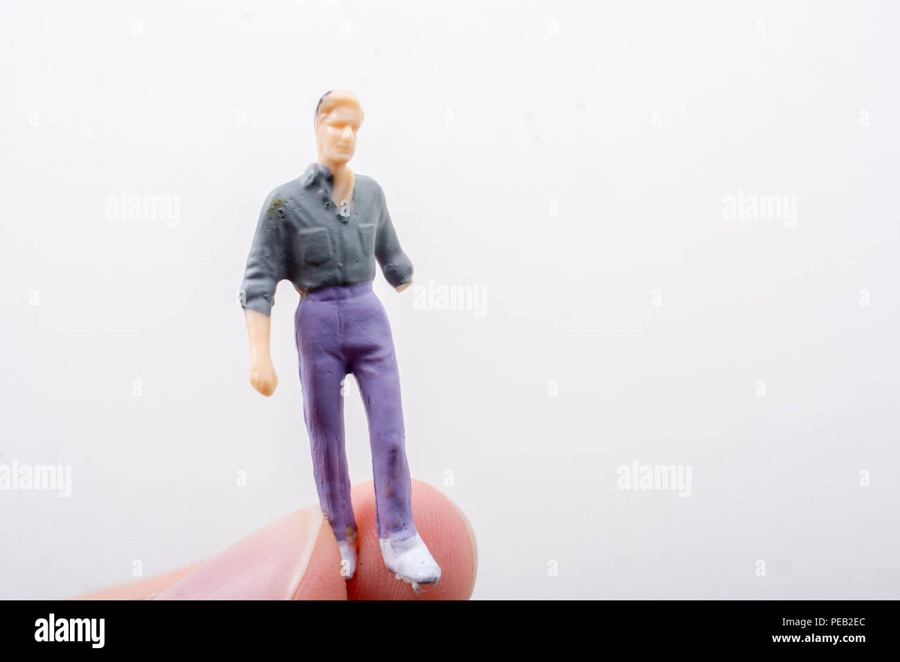 Tiny figurine of man miniature model in hand Stock Photo - Alamy