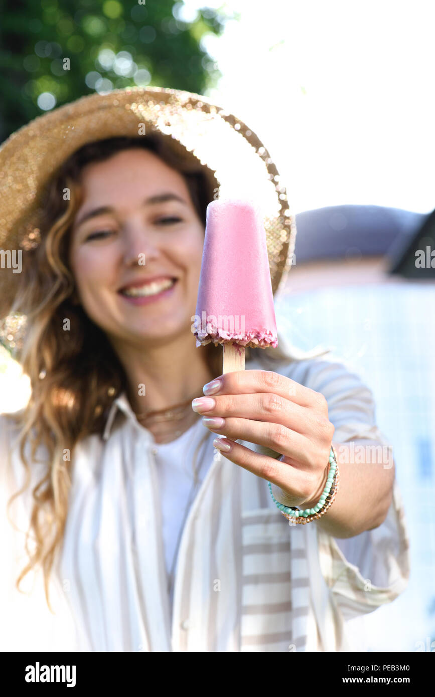 Fruit ice pop in hand of young woman Stock Photo - Alamy