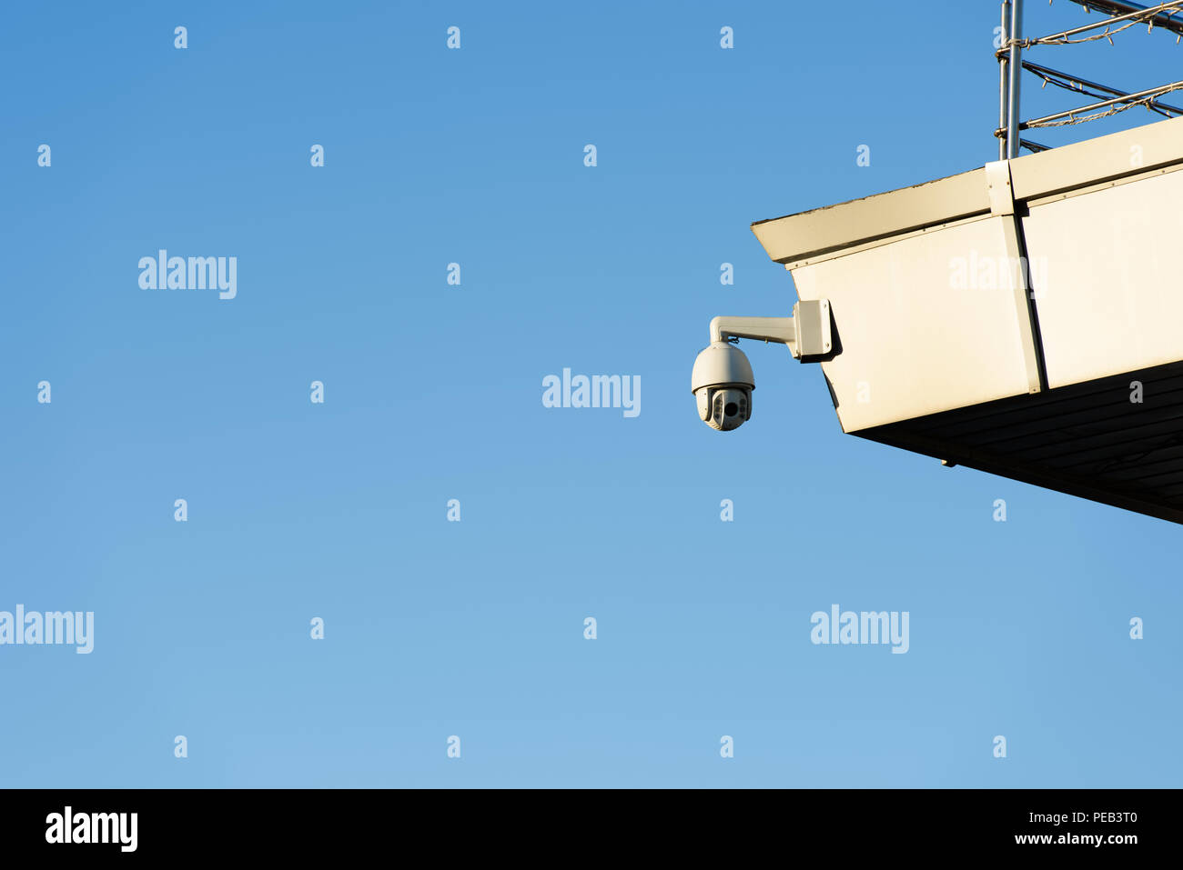 close up view of security camera on building facade with clear blue sky ...