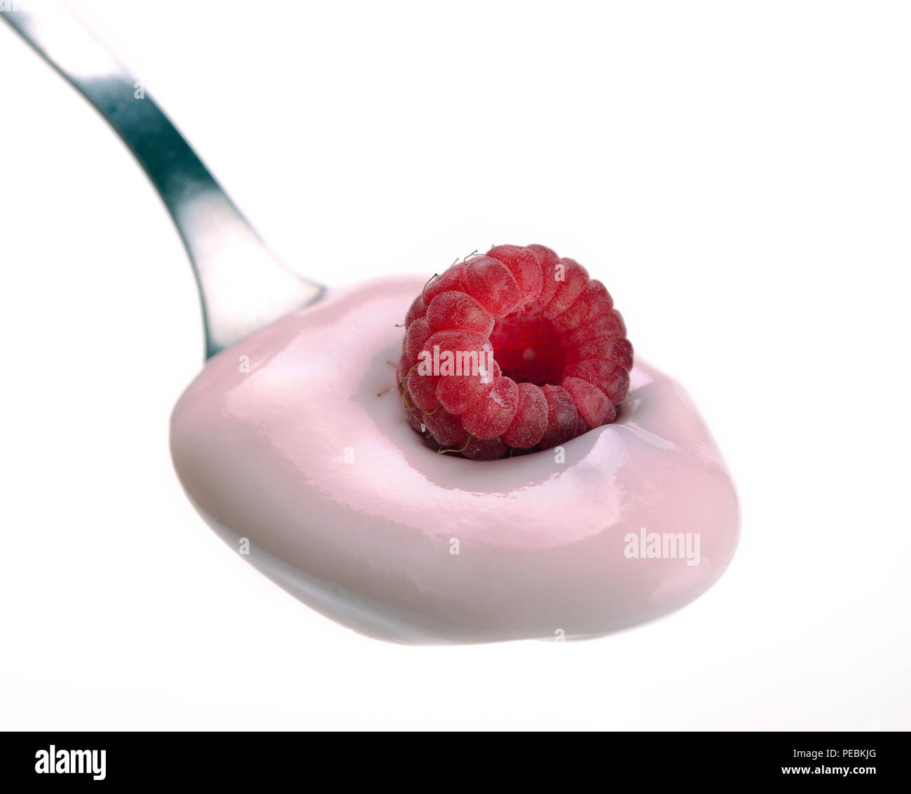 Spoon of yogurt with raspberry on top isolated on white Stock Photo - Alamy