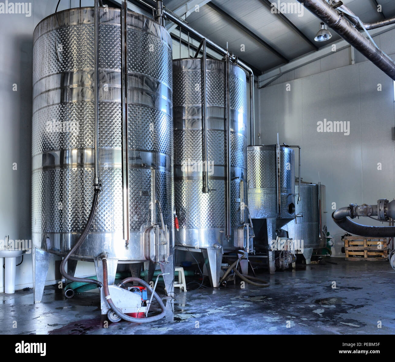 Stainless steel wine vats in a row inside the winery Stock Photo - Alamy