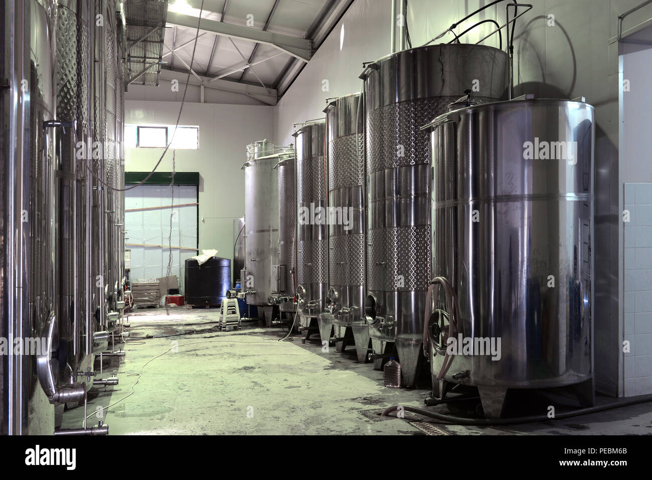 Stainless steel wine vats in a row inside the winery Stock Photo - Alamy