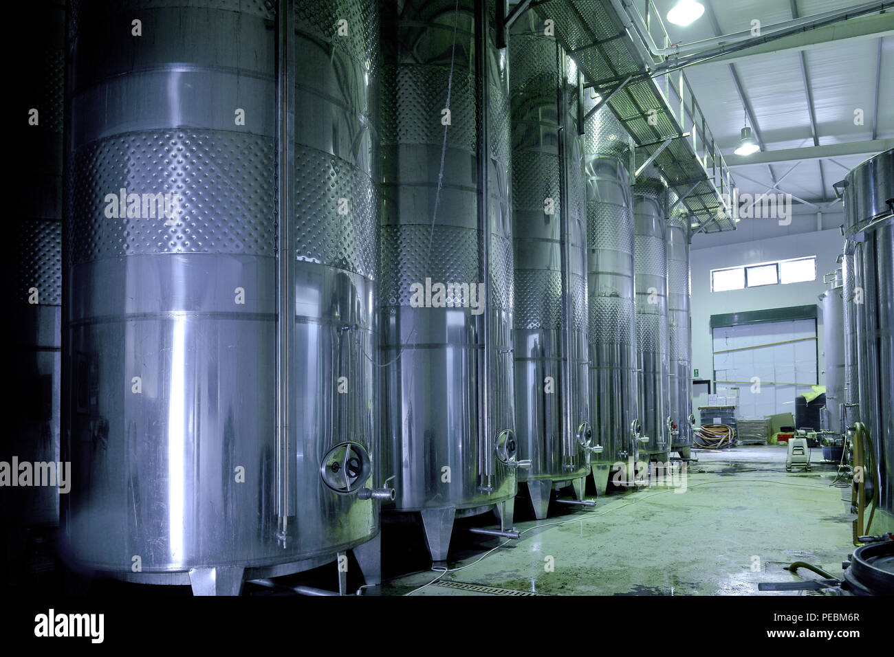 Stainless steel wine vats in a row inside the winery Stock Photo - Alamy