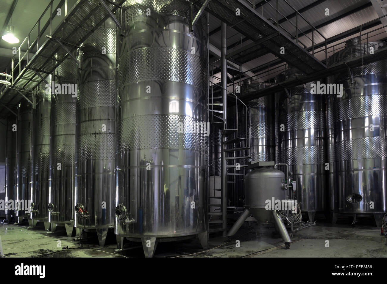 Stainless steel wine vats in a row inside the winery Stock Photo - Alamy