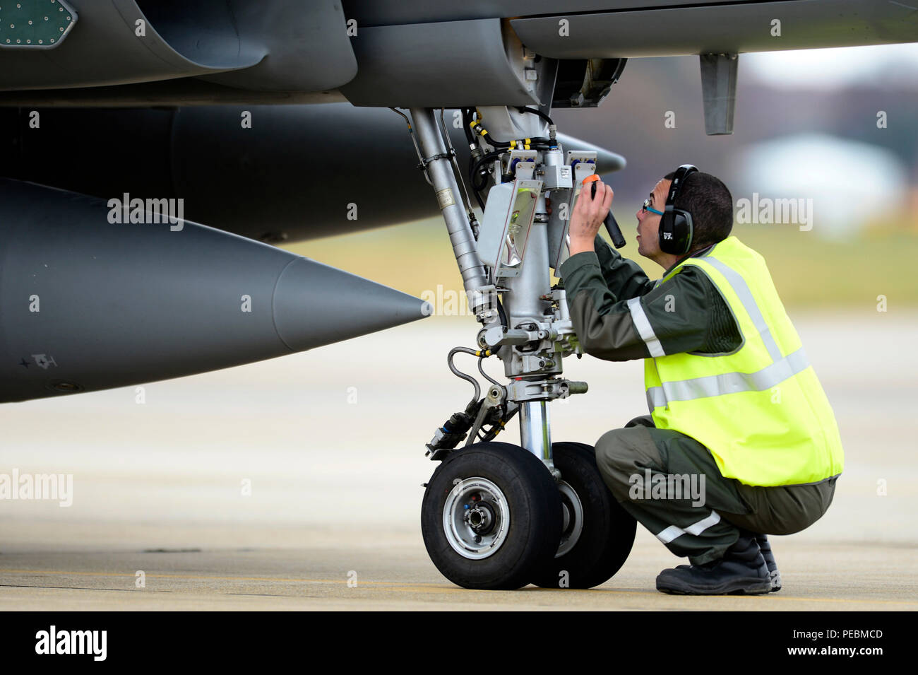 A member of the French Air Force (FrAF) performs post-flight checks on ...