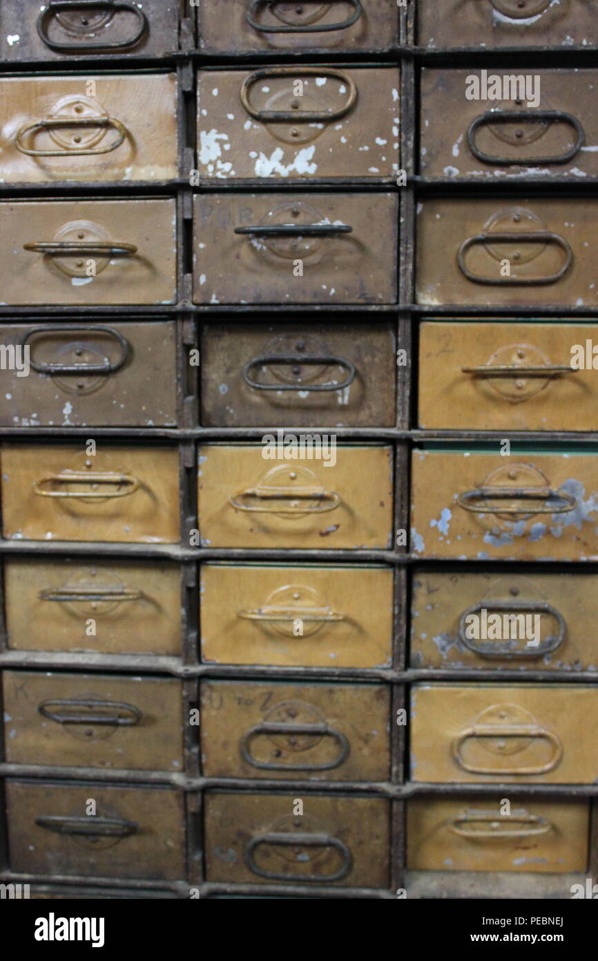 Furniture of small metal drawers stacked in vertical lines with handles ...